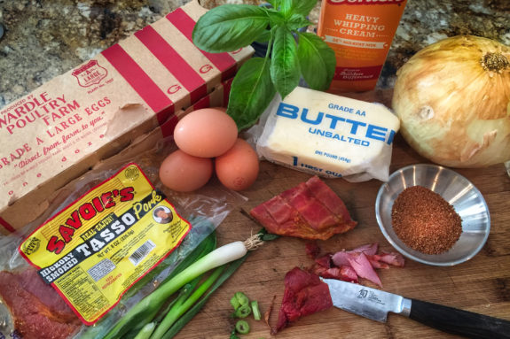 Baked Eggs in Tasso Cream is a French with Cajun smoked meat flavor.